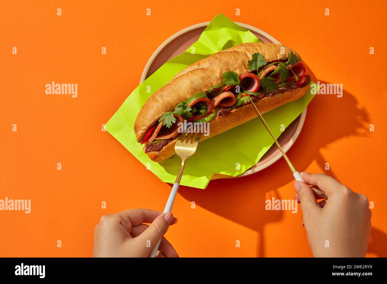 Two woman hands holding a golden knife and fork preparing to eat bread ...
