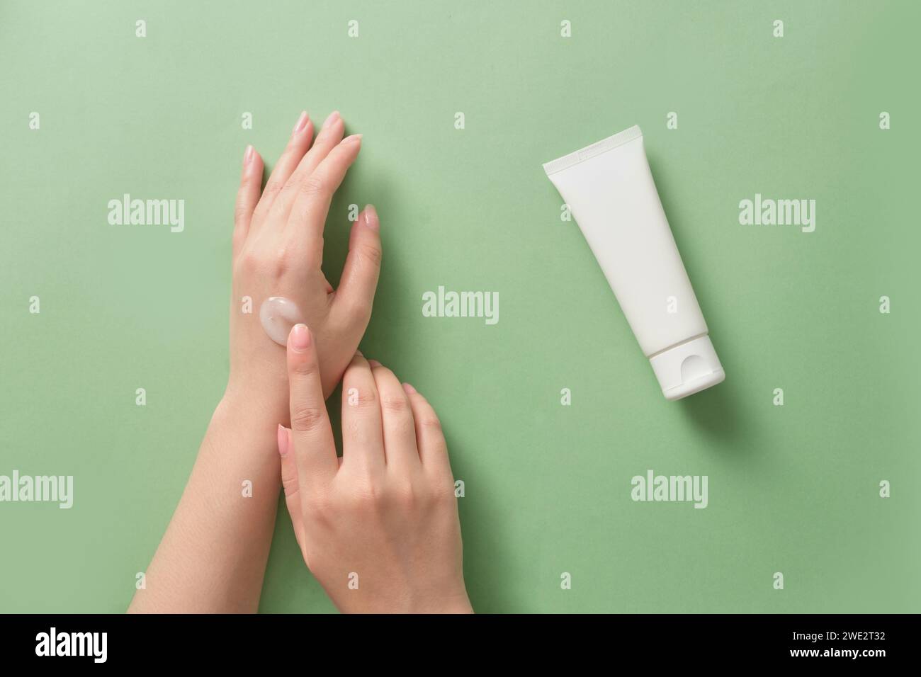 Female hands are applying cream texture on the back of the other and an ...