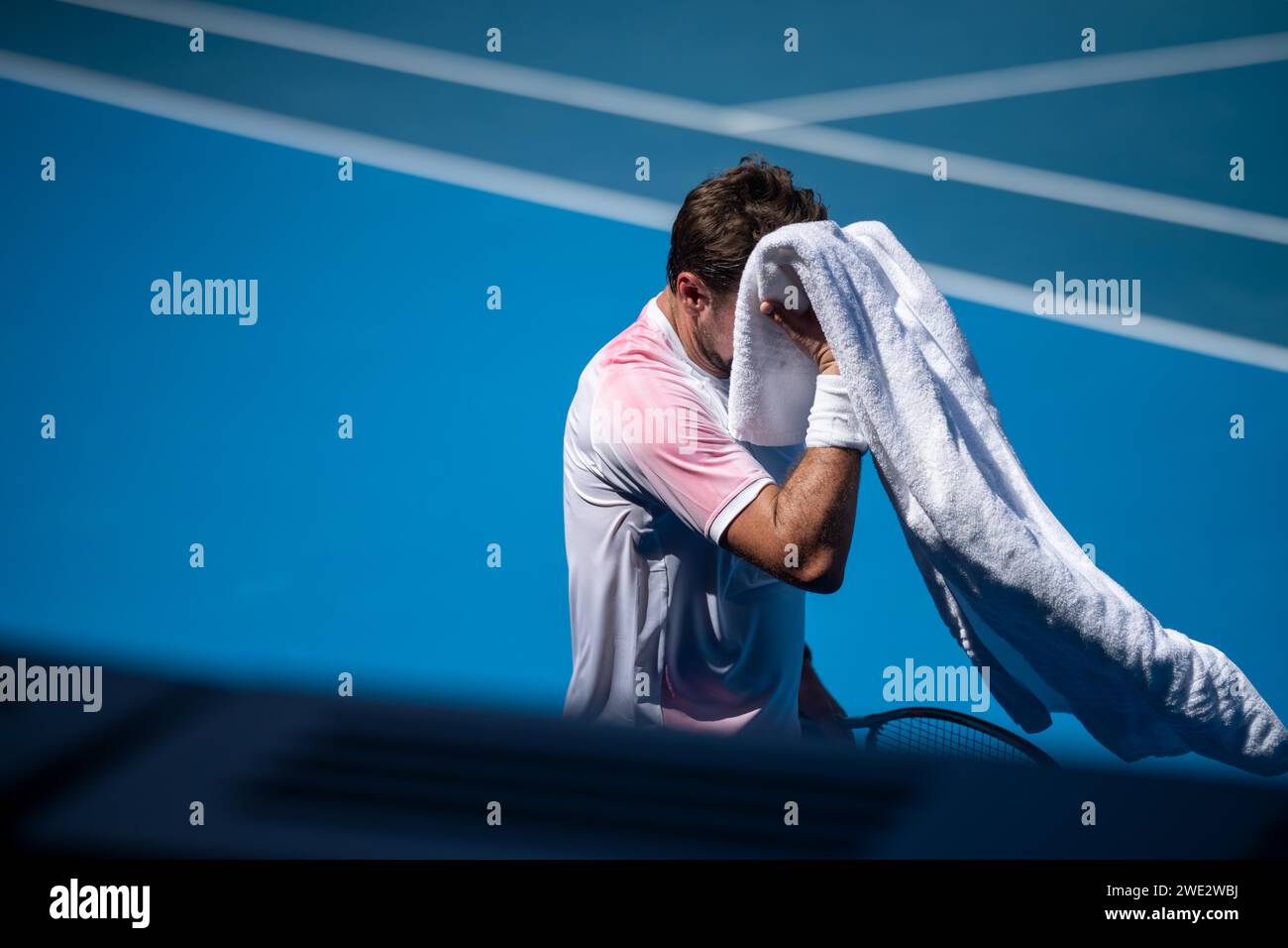 tennis player drying off with a towel on a tennis court in summer in ...