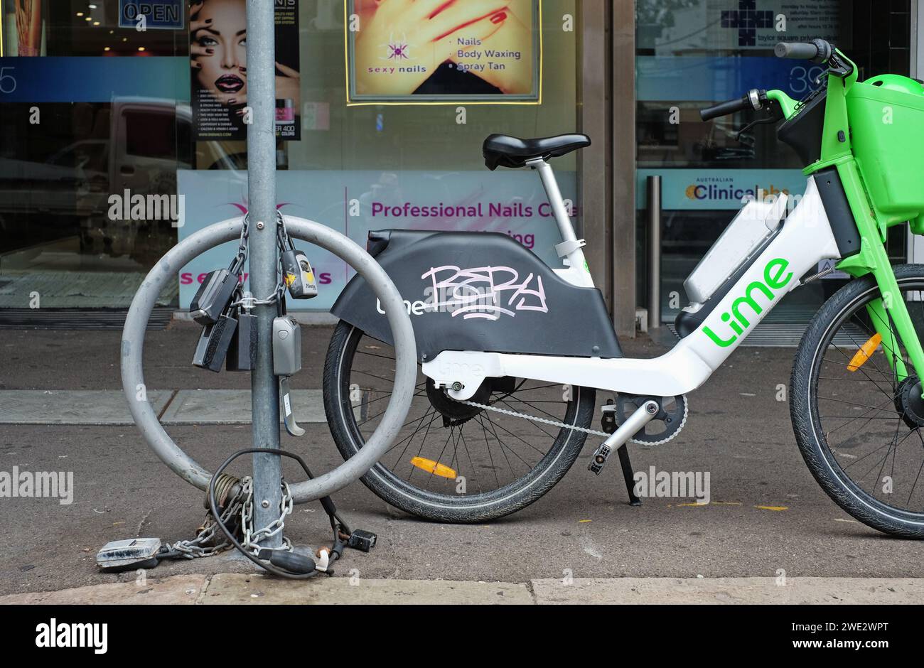 Shop fronts, a lime bike and key safe boxes on chains chains around a ...