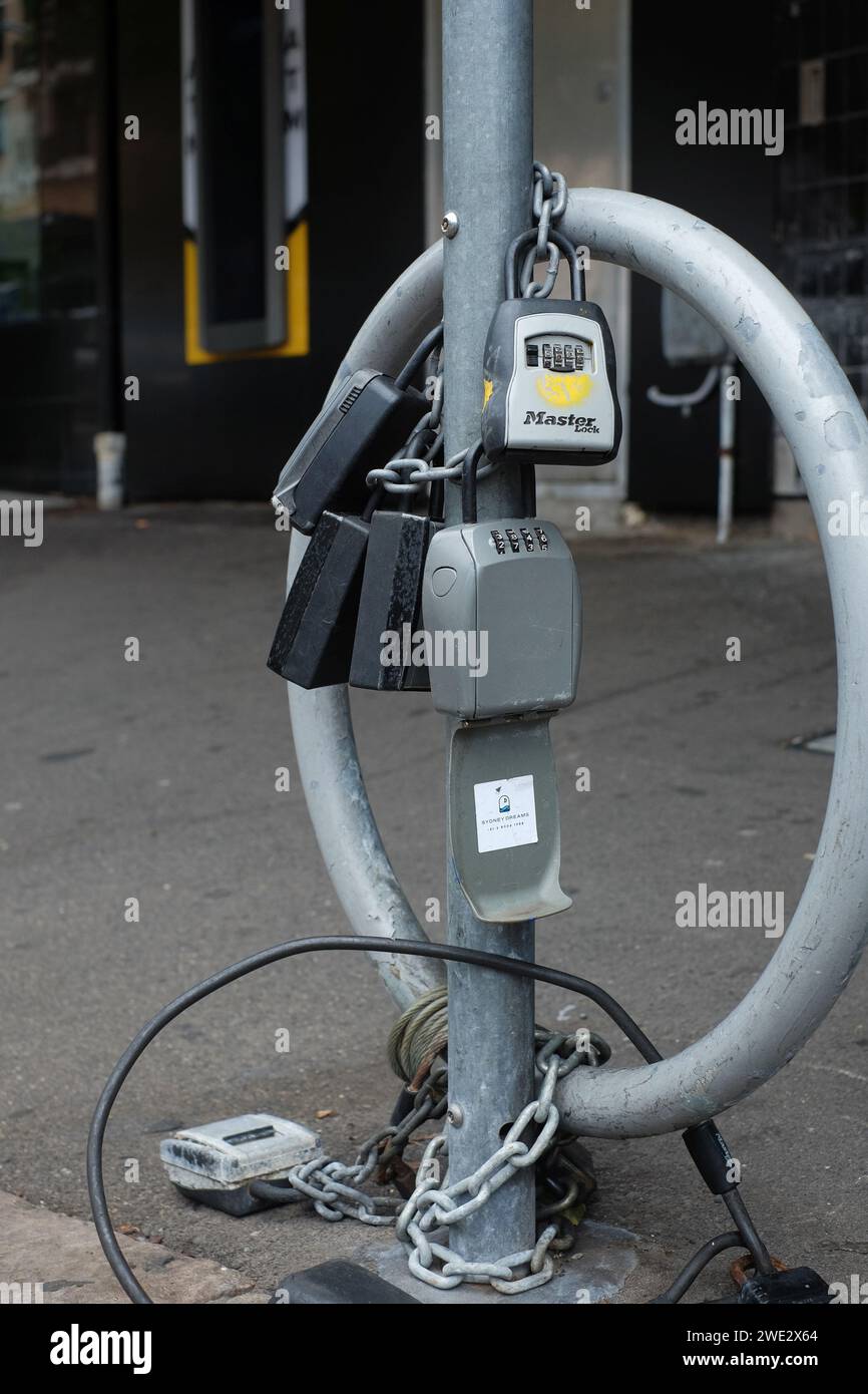 Detail of combination lock key safe boxes held by chains around a metal ...