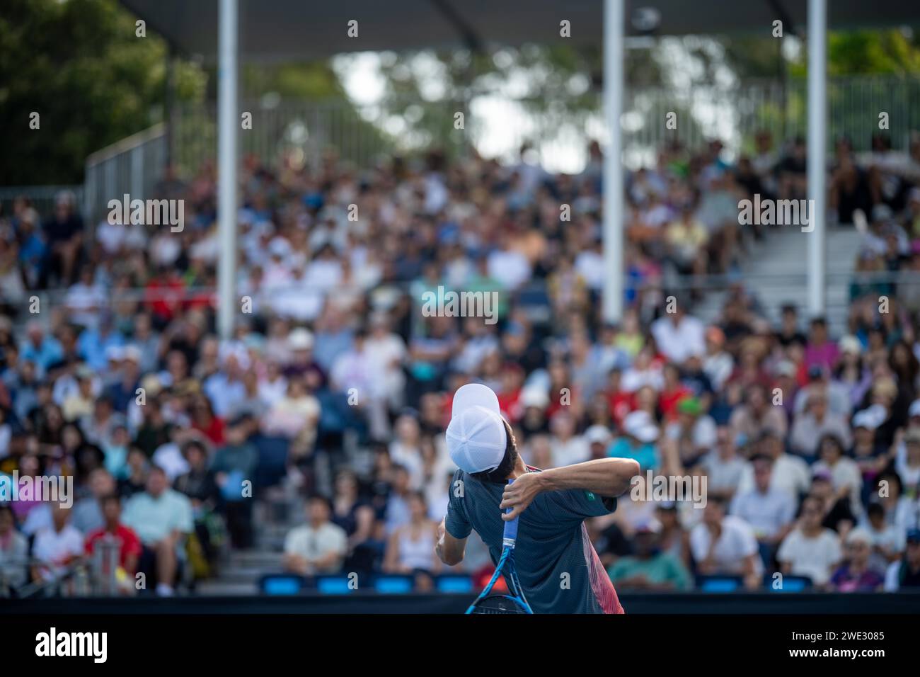 Tourist with backpacks in a crowd watching a sporting event in a ...