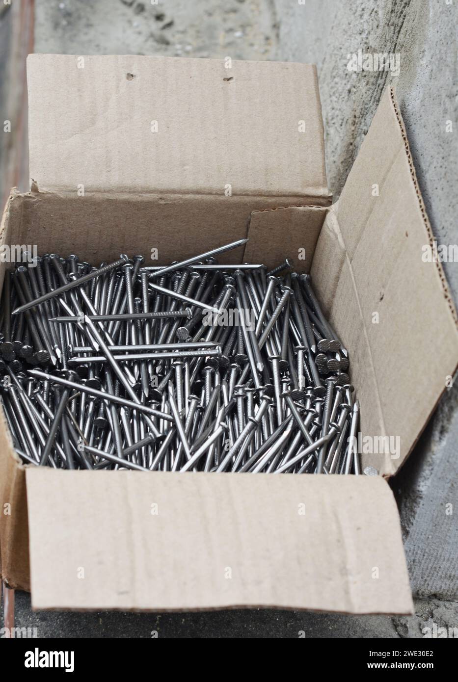 A box full of long metal building nails for a house construction Stock ...