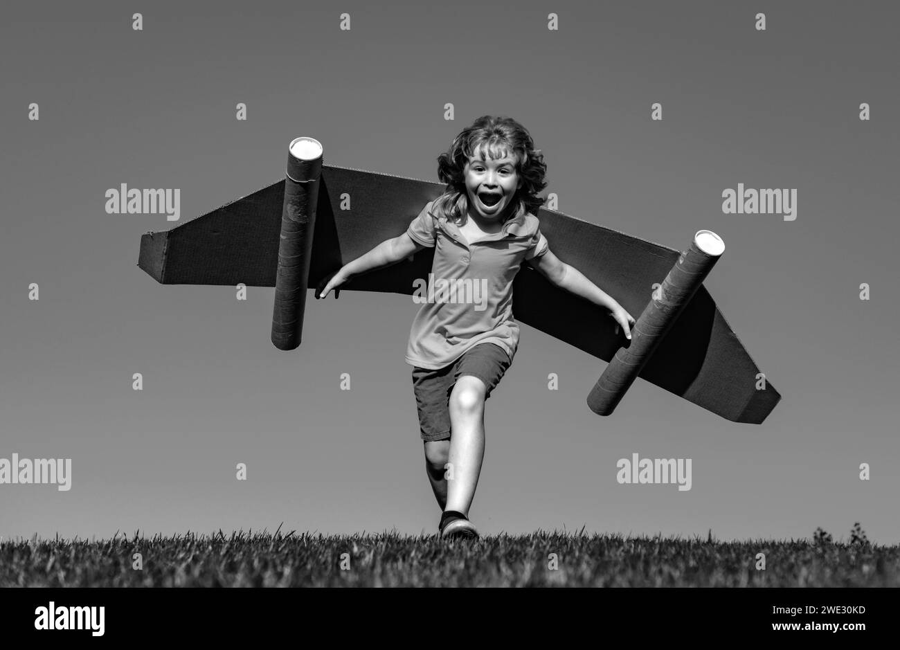 Excited kid with jet pack superhero. Child pilot running against summer ...