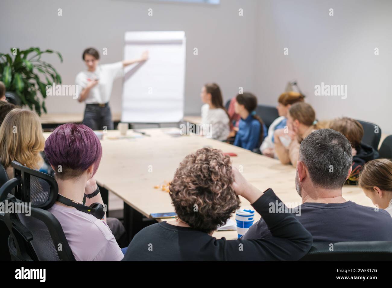 Focused audience at a corporate training session with presenter blurred ...