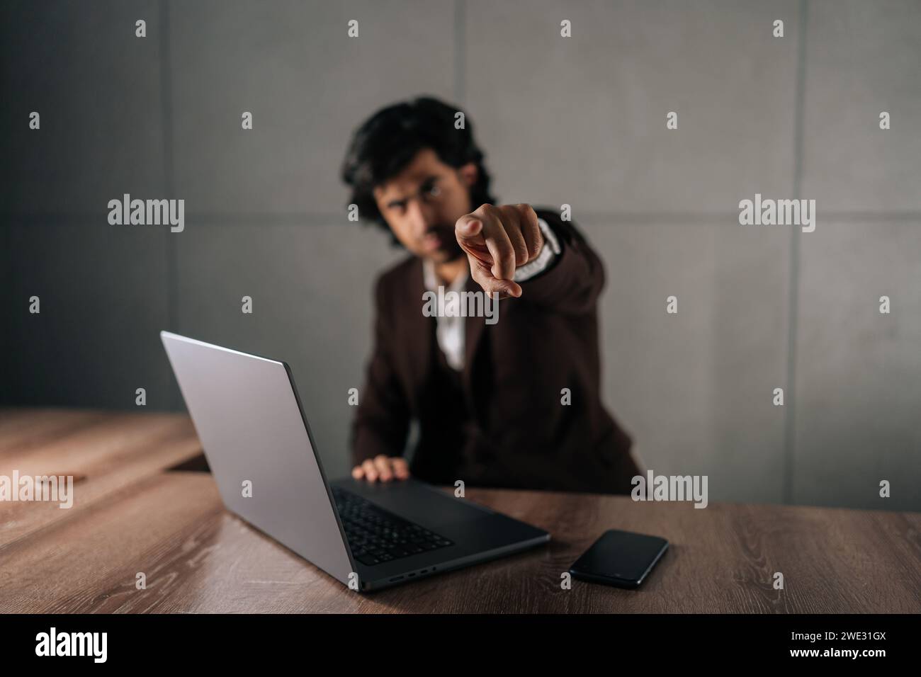 Portrait of serious successful businessman in suit looking at camera ...