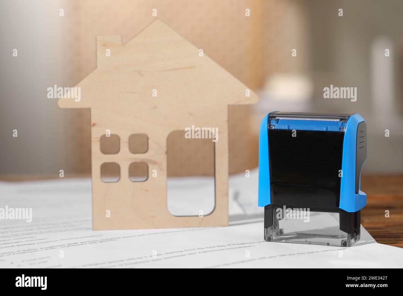 Notary contract. Stamp, figure of house and document on table, closeup ...