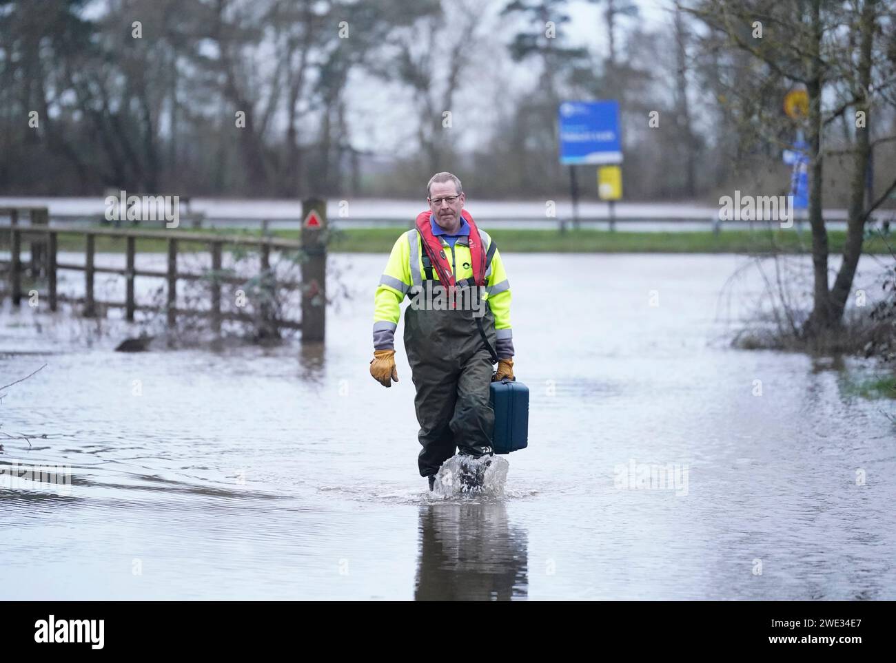 An Canal and River Trust worker walks through flood water at Naburn ...