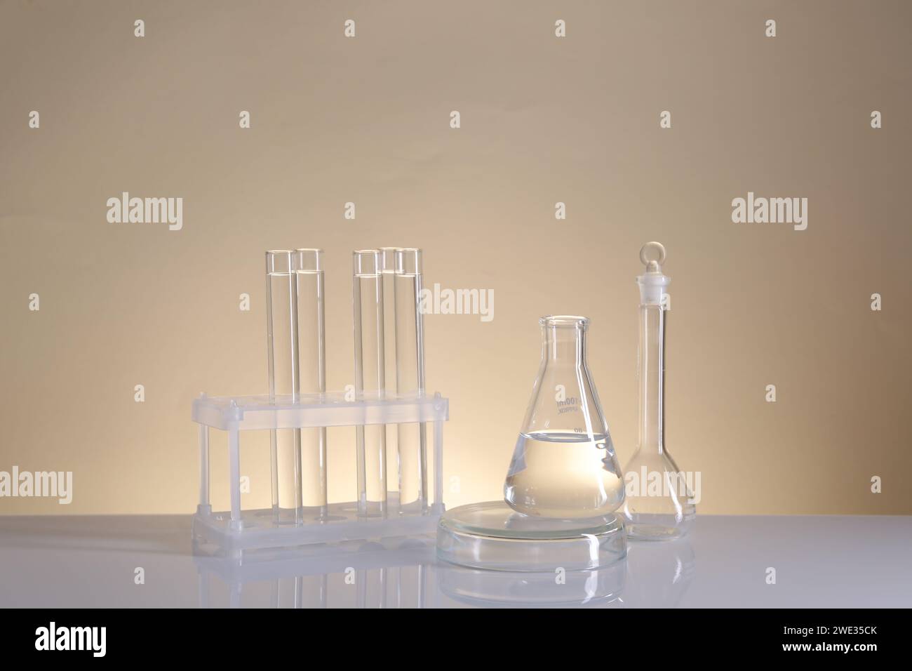 Laboratory analysis. Different glassware on table against beige ...