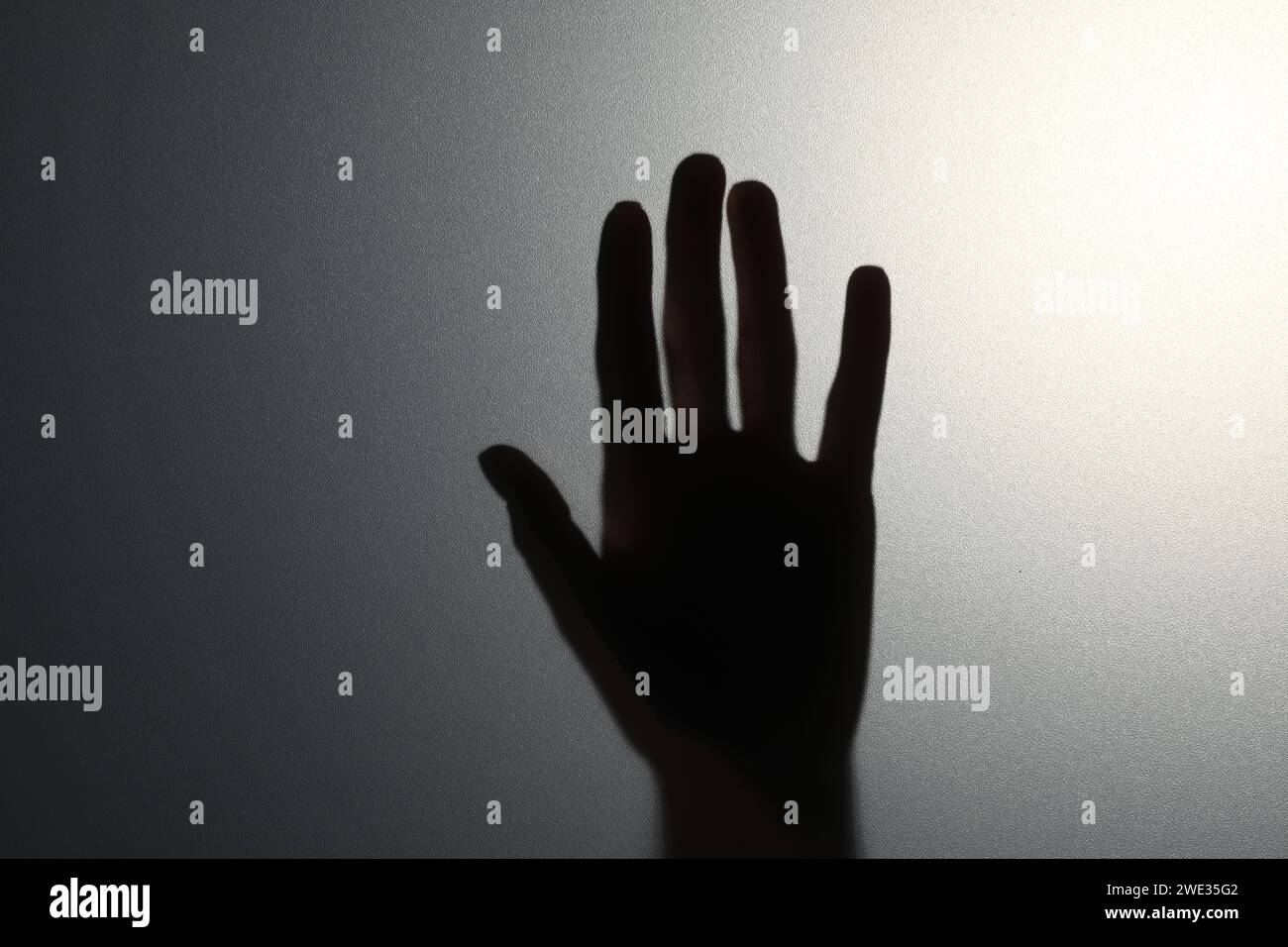 Silhouette of creepy ghost behind glass against grey background ...