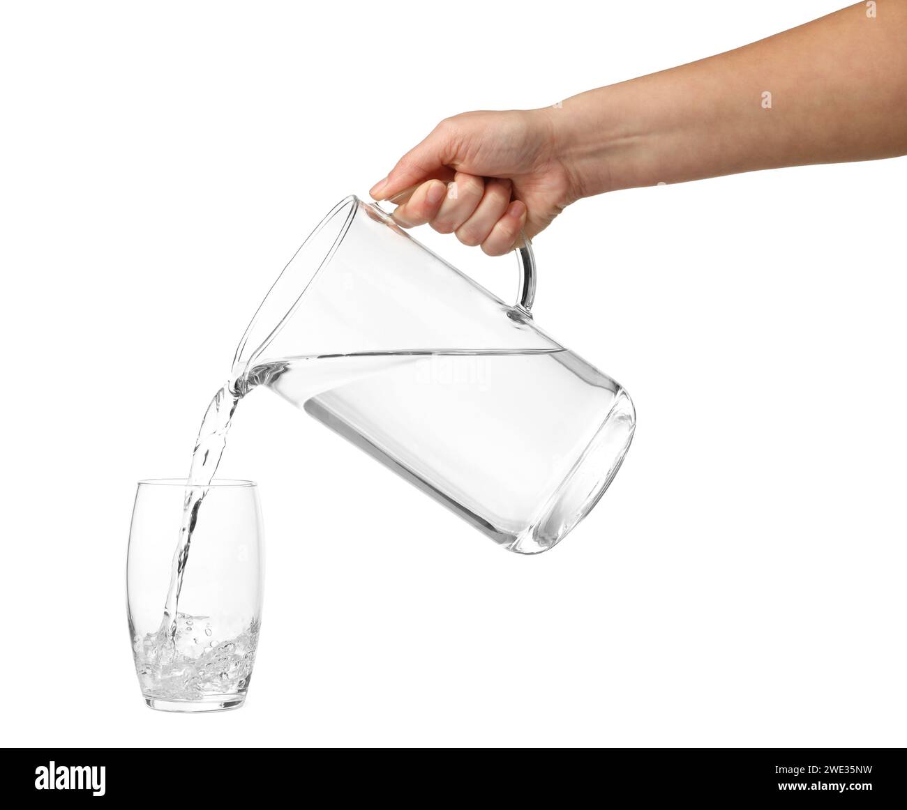 Woman pouring water from jug into glass on white background, closeup ...