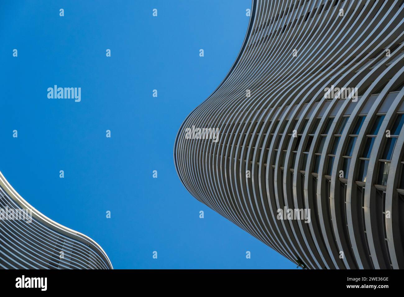 Curvilinear modern skyscrapers soar against a clear blue sky ...