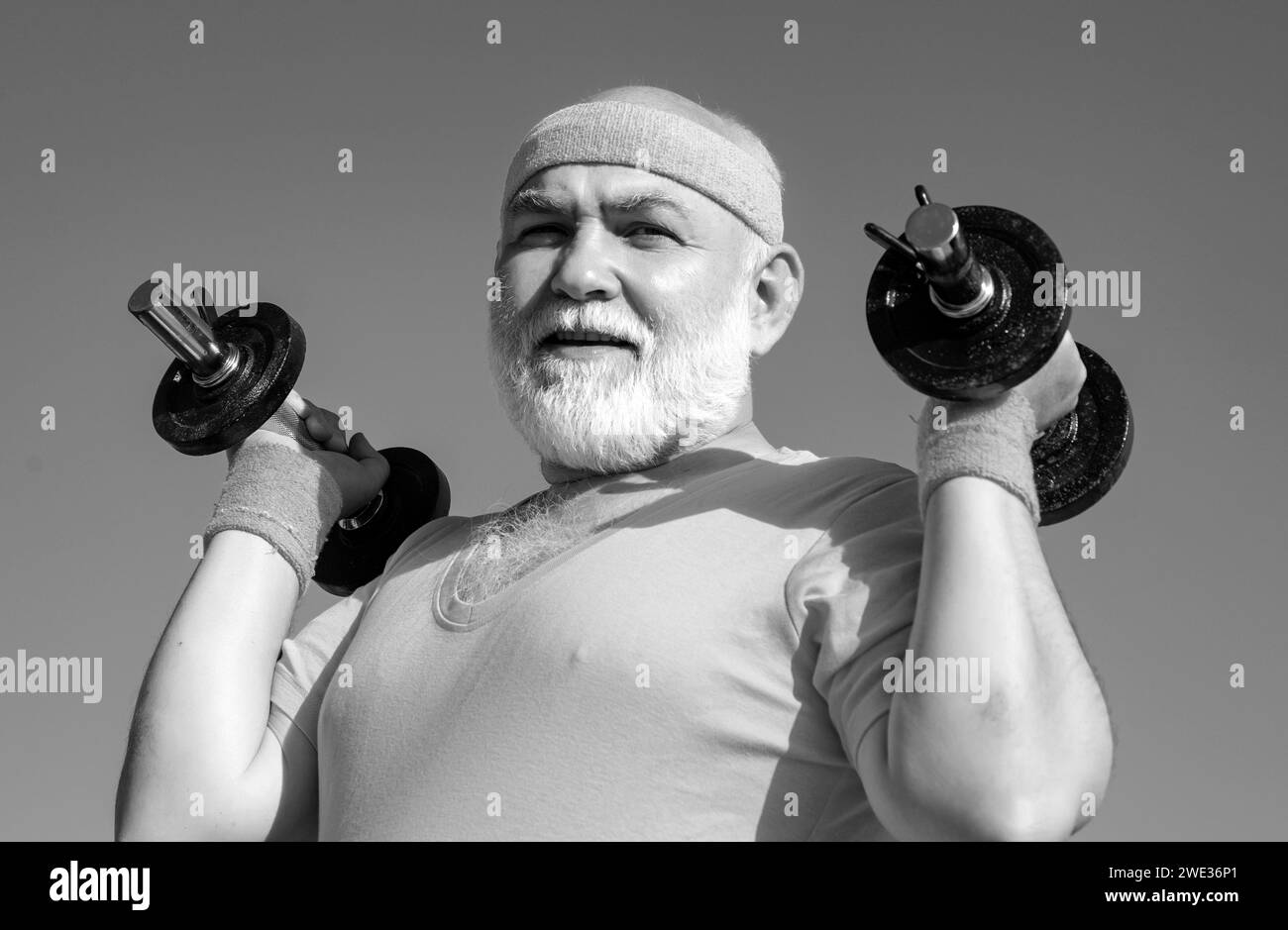 Senior sport man exercising with dumbbell. Be in motion. Grandfather ...