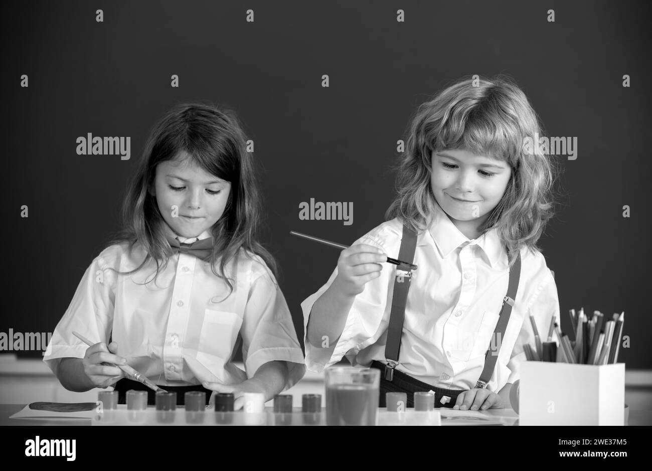 School children drawing a colorful pictures with pencil crayons in ...