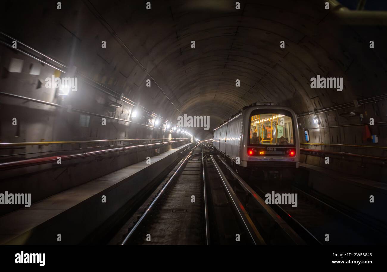 A metro train on the line M5 travels through a tunnel in Milan, Italy ...