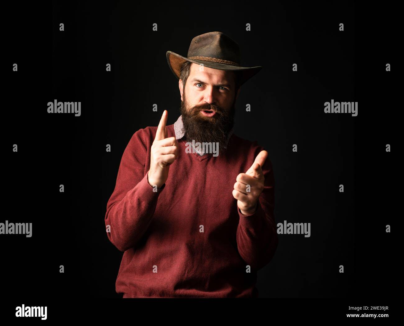 Bearded cowboy man in cowboy hat. Wild west guns, finger revolver ...