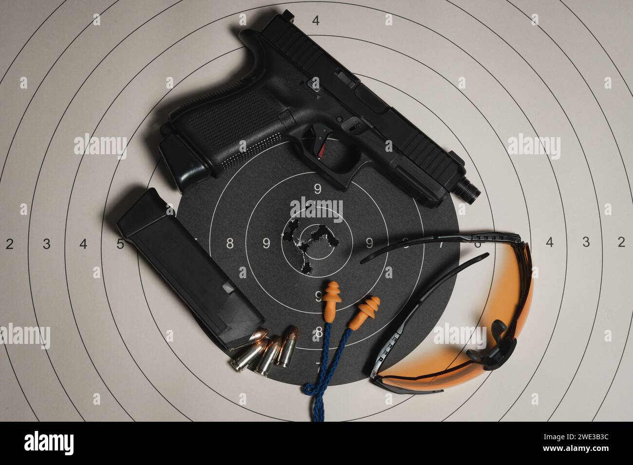 A shooting target with bullet holes in the center, a G19gen5 pistol ...