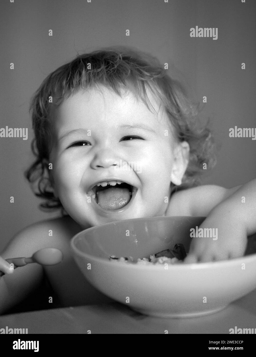 Launching child eat. Smiling baby eating food. Family, food, child ...