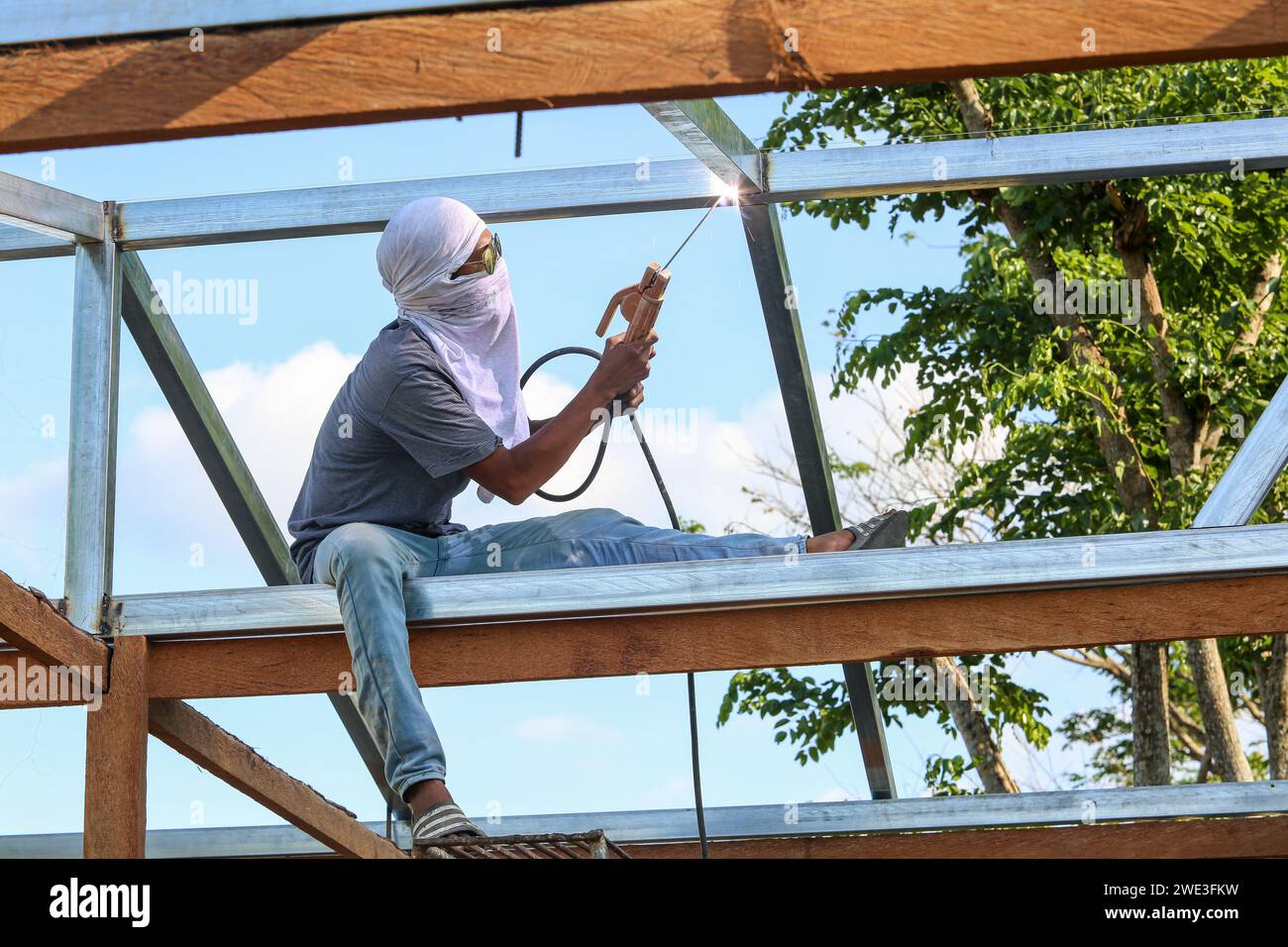 Filipino construction worker welding on roof metal structure of a Bahay ...