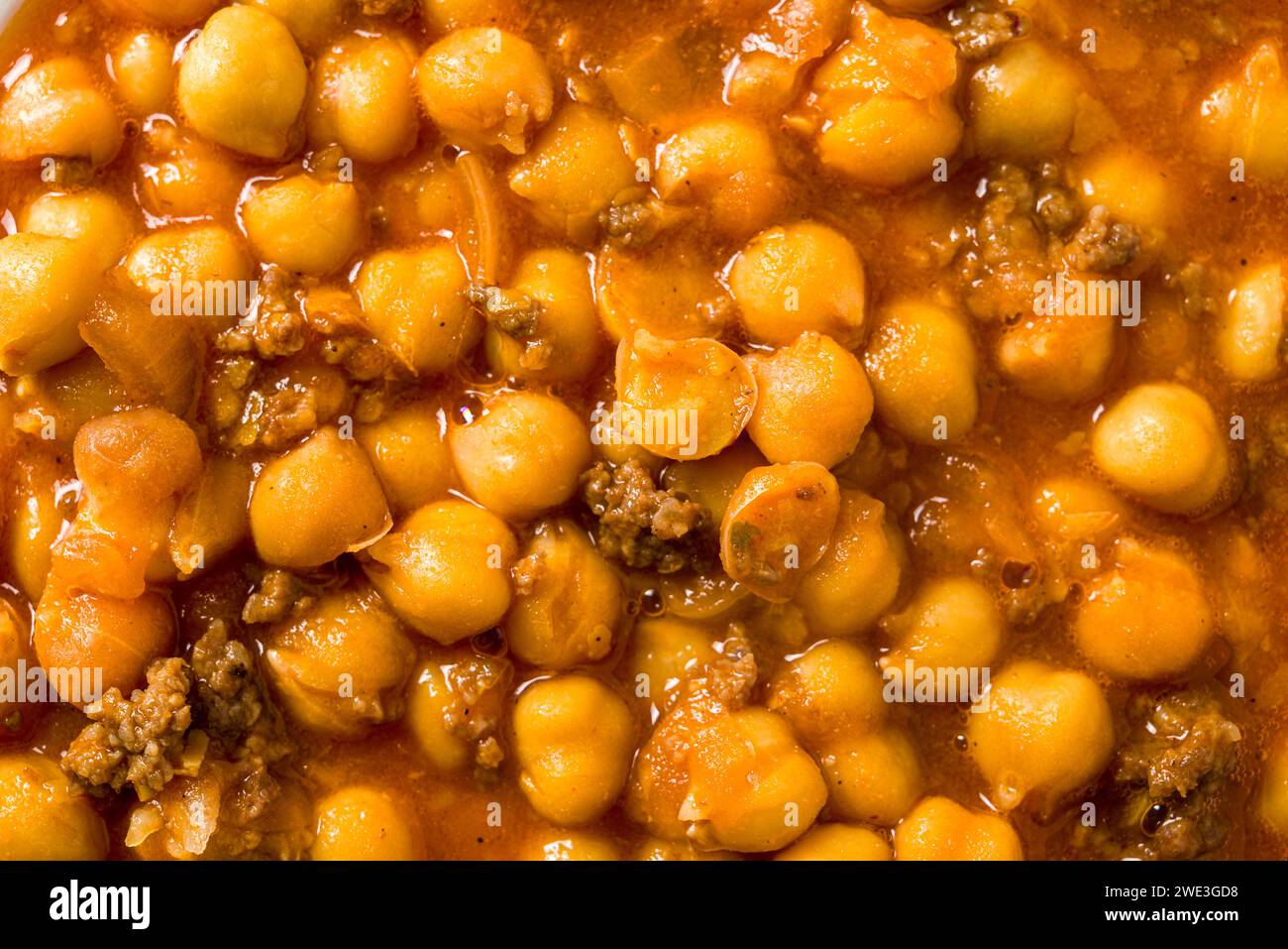 Chickpea stew with minced meat on a white porcelain plate on a stone ...