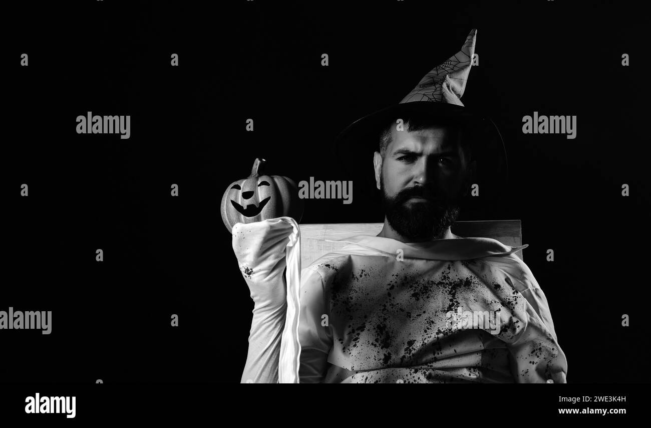 Halloween man with pumpkin in darkness. Wizard, sorcerer, warlock ...