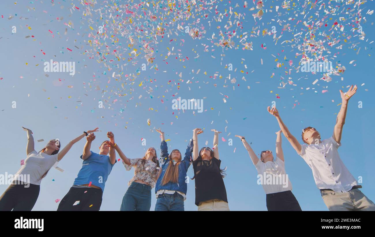 Friends toss colorful paper confetti from their hands Stock Photo - Alamy