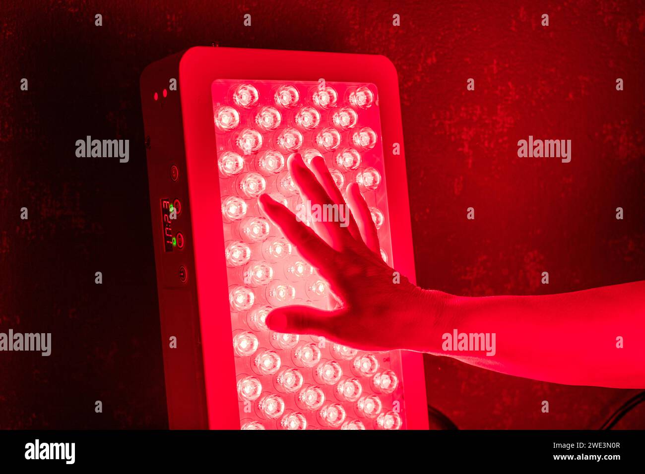 Closeup of hand touching Red Light Therapy Panel LEDs Stock Photo - Alamy