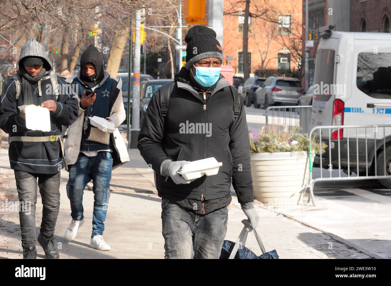 New York, United States. 22nd Jan, 2024. Migrants carry food as they ...