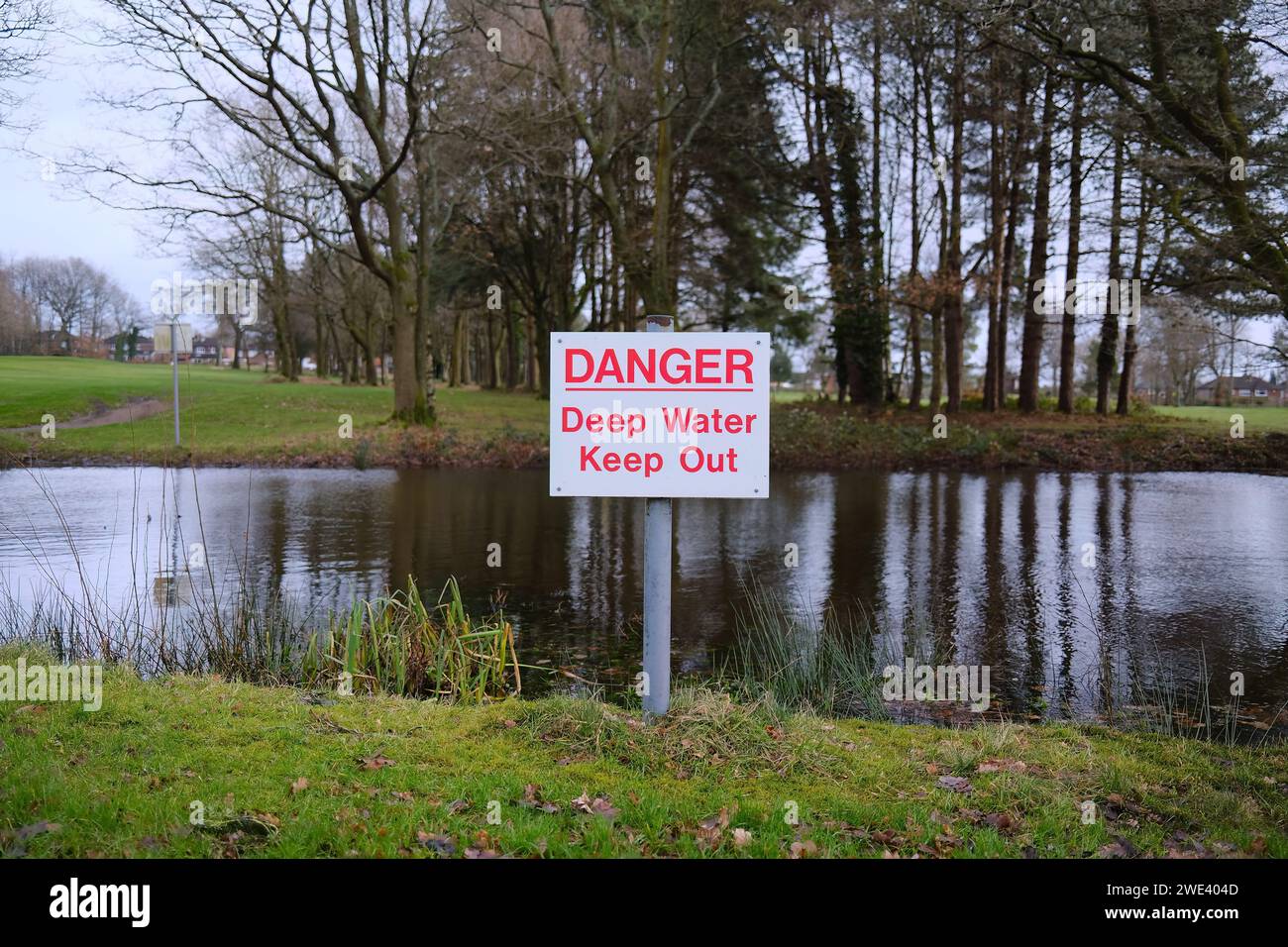 danger deep water warning sign by a water filled pond risk to the ...