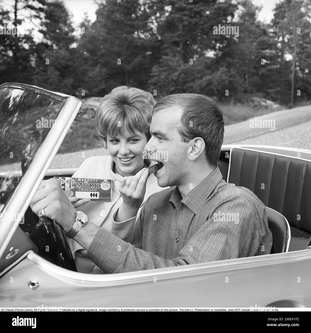 Mazetti chocolate. A young couple sit together in a convertible car on ...