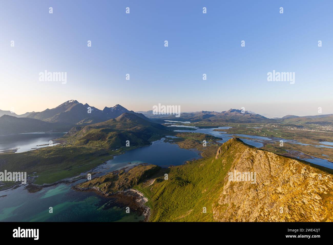 The midnight sun casts a golden glow on Offersoykammen, with the vivid ...