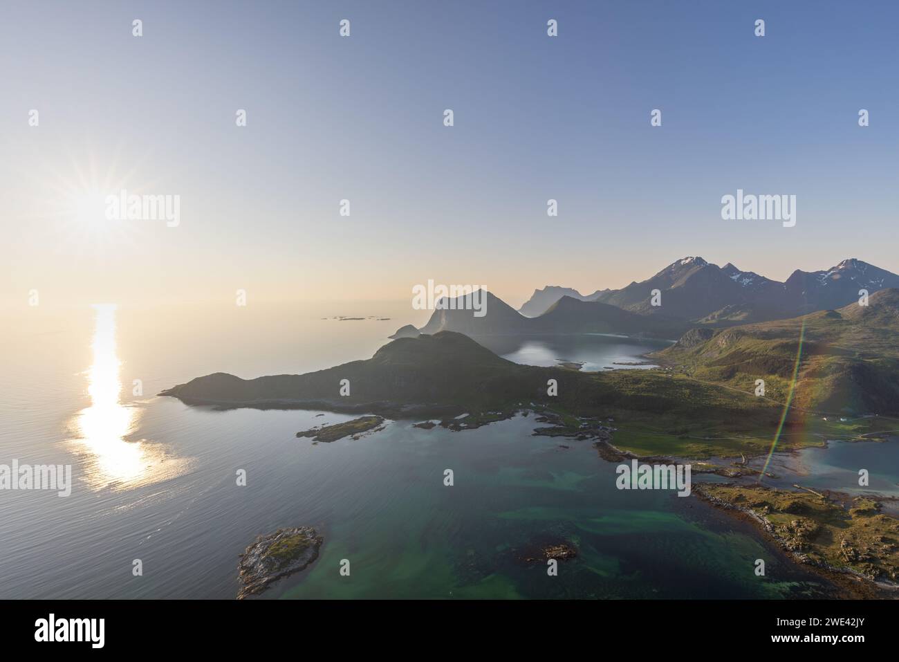 The midnight sun hovers over Offersoykammen, casting a shimmering path ...