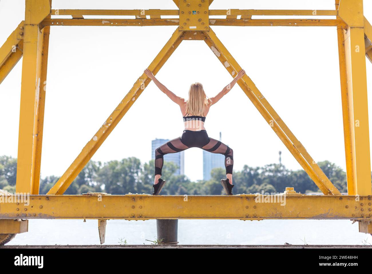 back view of fit muscular woman exercising on old metal crane Stock ...