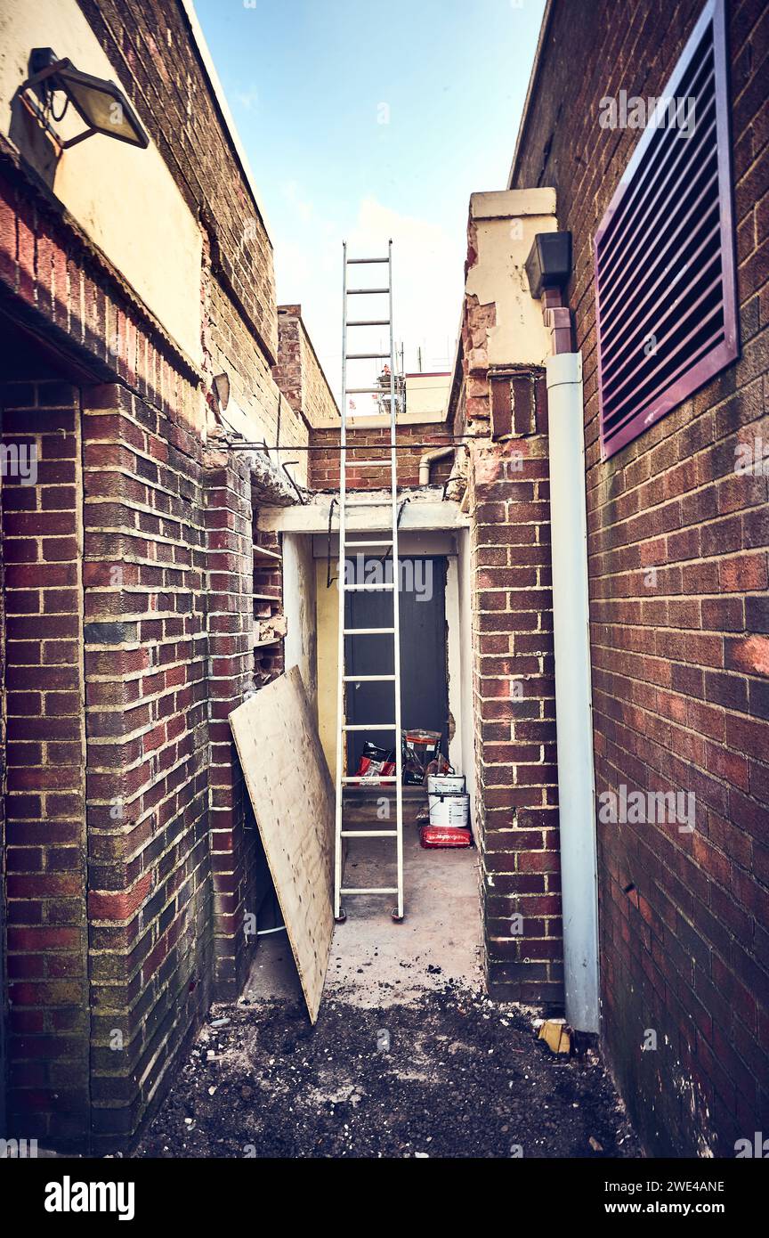 Ladders against wall leading on to roof Stock Photo - Alamy