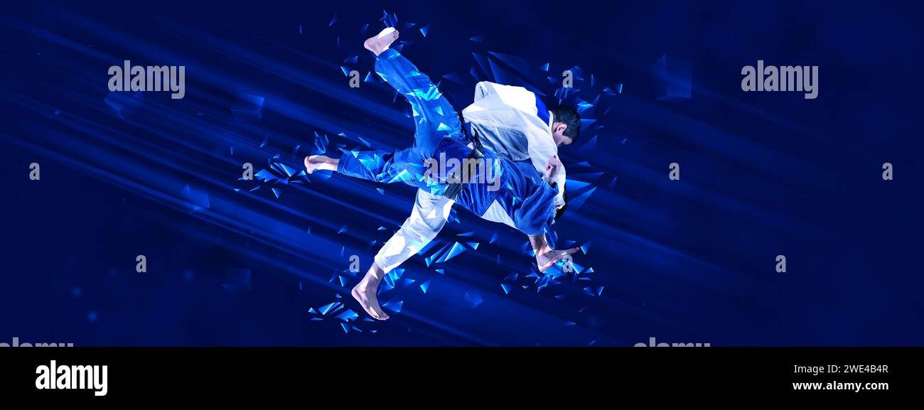 Two men, karate fighters in kimono training on blue background with ...