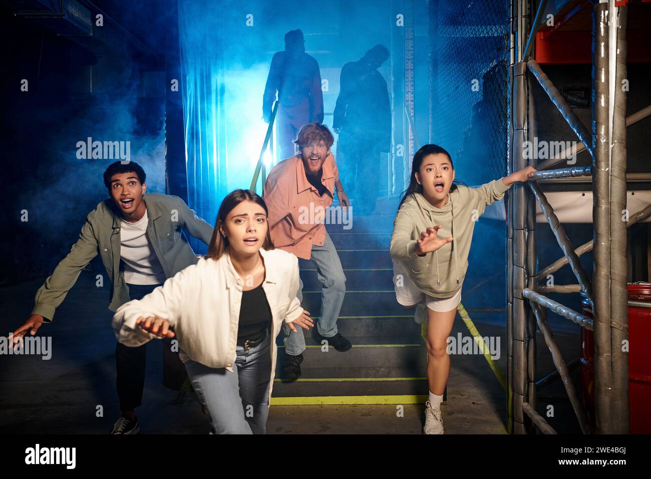 four young multicultural friends running from scary people in gas masks ...