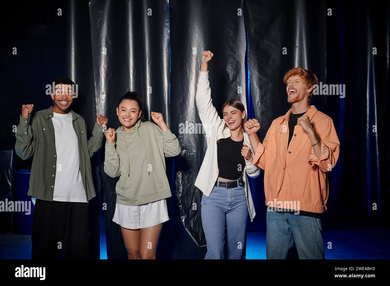 group of four multicultural friends celebrating success in an escape ...