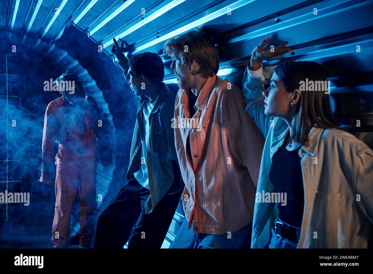 scared diverse friends standing in tunnel near freaky people in gas ...