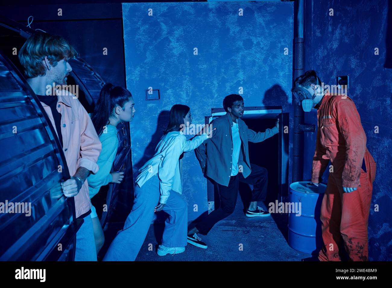 Multicultural group of friends escaping from man in gas mask during ...