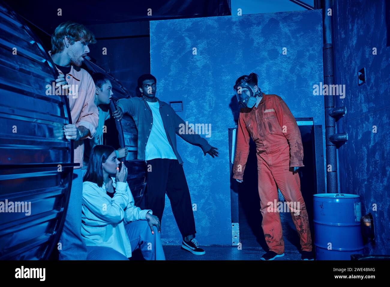 Multicultural group of people hiding from man in gas mask during escape ...