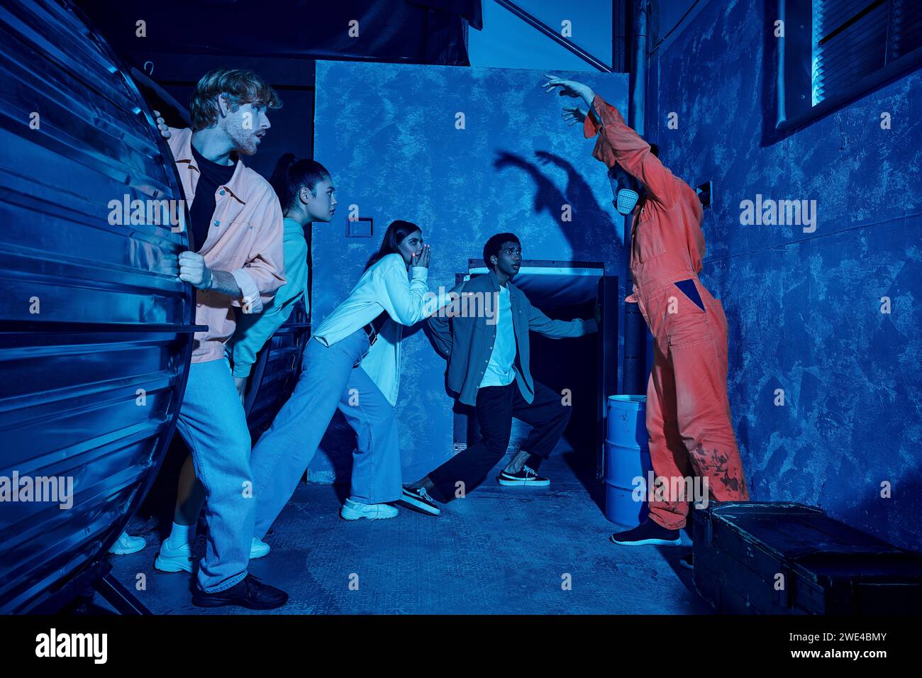 Multicultural group of people escaping from man in gas mask during ...
