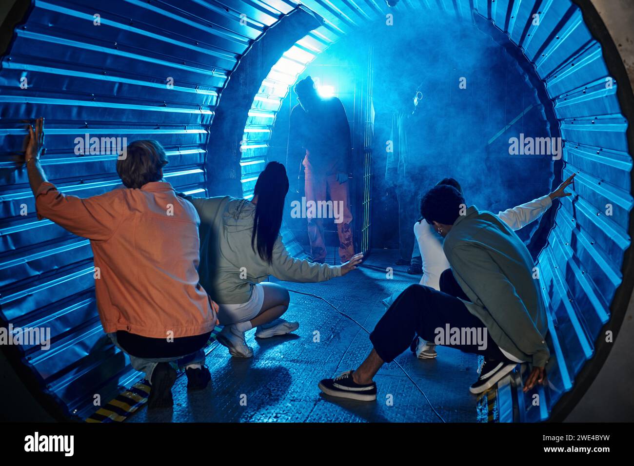 young group of people sitting in tunnel and looking at scary people in ...