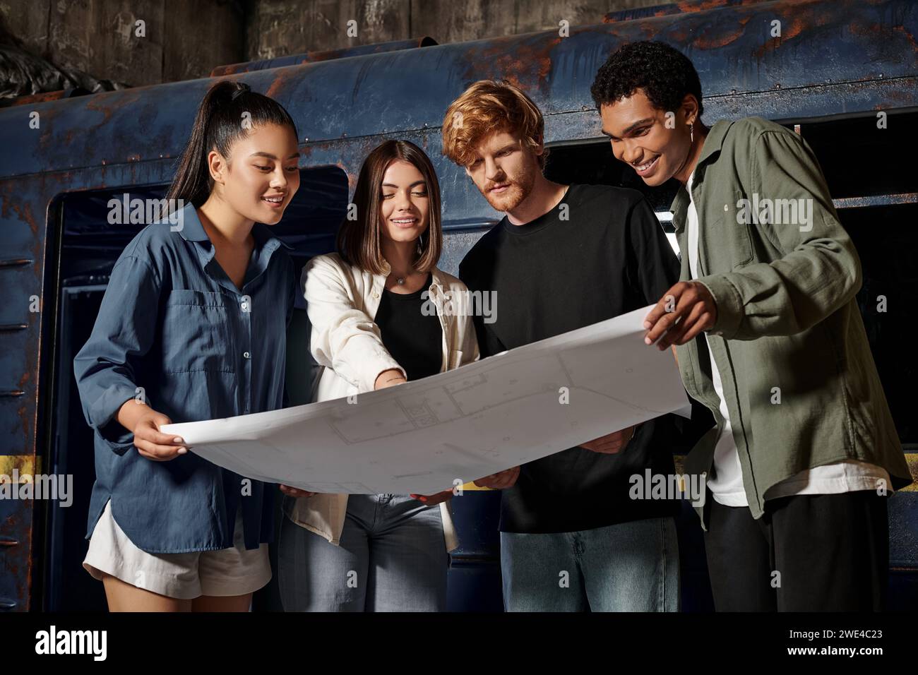 group of happy young multicultural friends solving quest task while ...