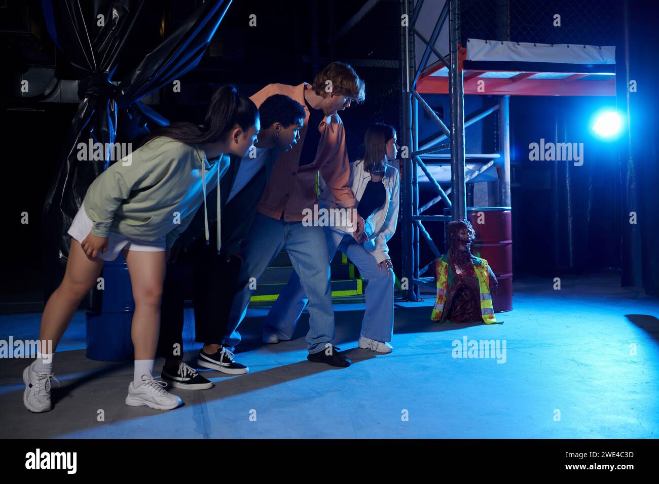 four diverse and curious young friends looking at scary mannequin ...
