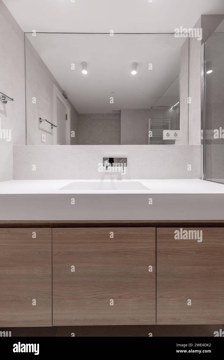 A modern design bathroom with an integrated mirror that runs along the ...