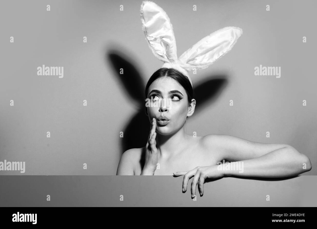 Surprised young woman wearing rabbit ears isolated on pink Stock Photo ...