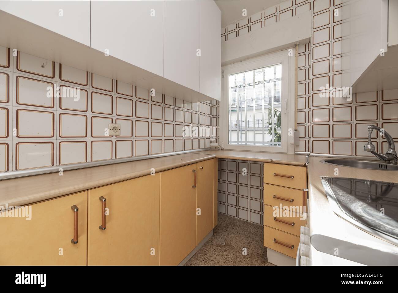 A kitchen with old furniture and tiles on the ground floor of a house ...