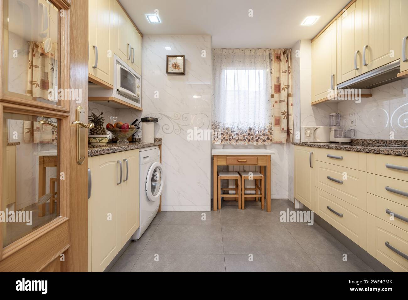 A conventional kitchen with cream-colored cabinets with large metal ...