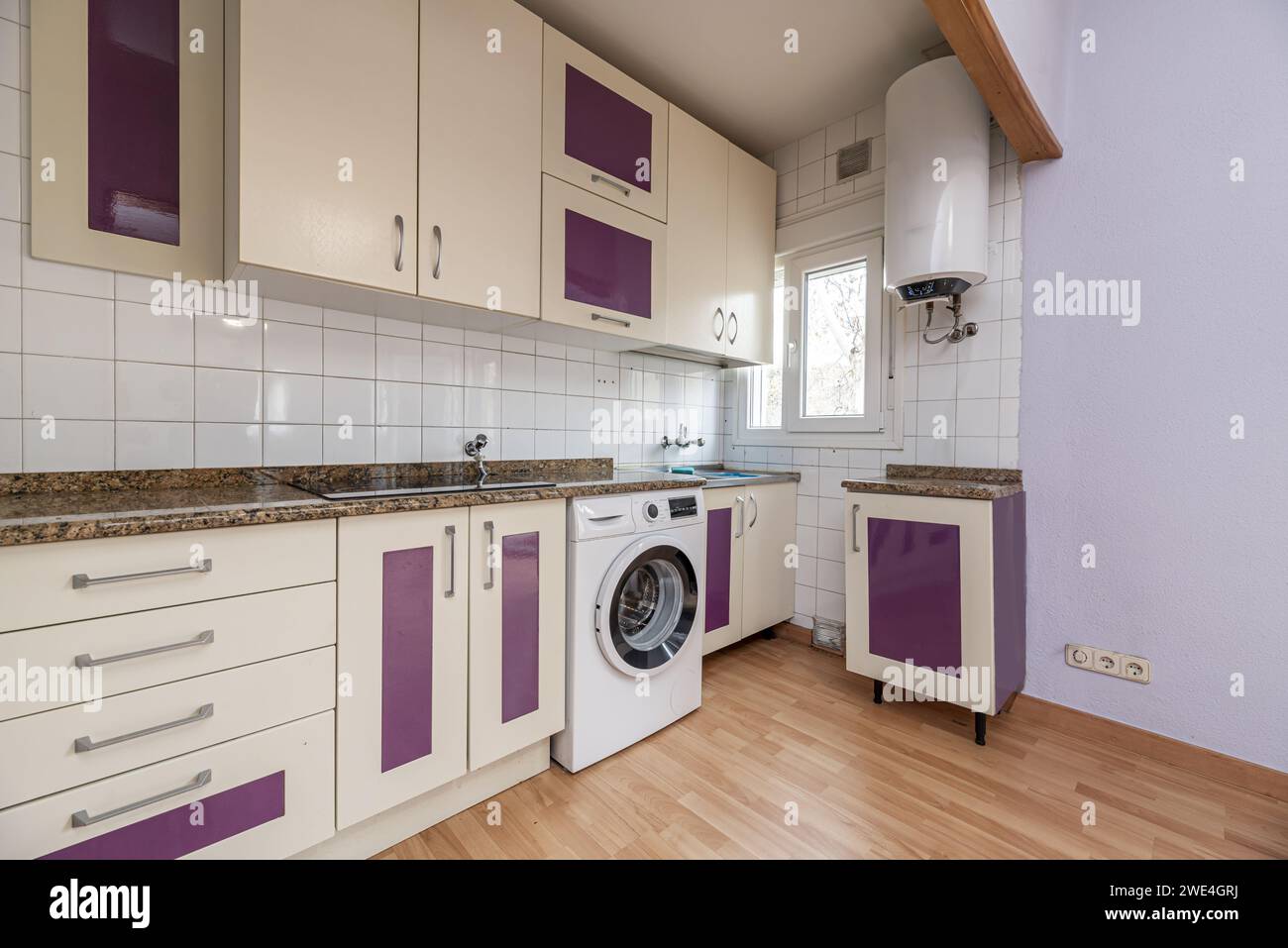 Small open kitchen in a loft-style apartment with various fuchsia tones ...