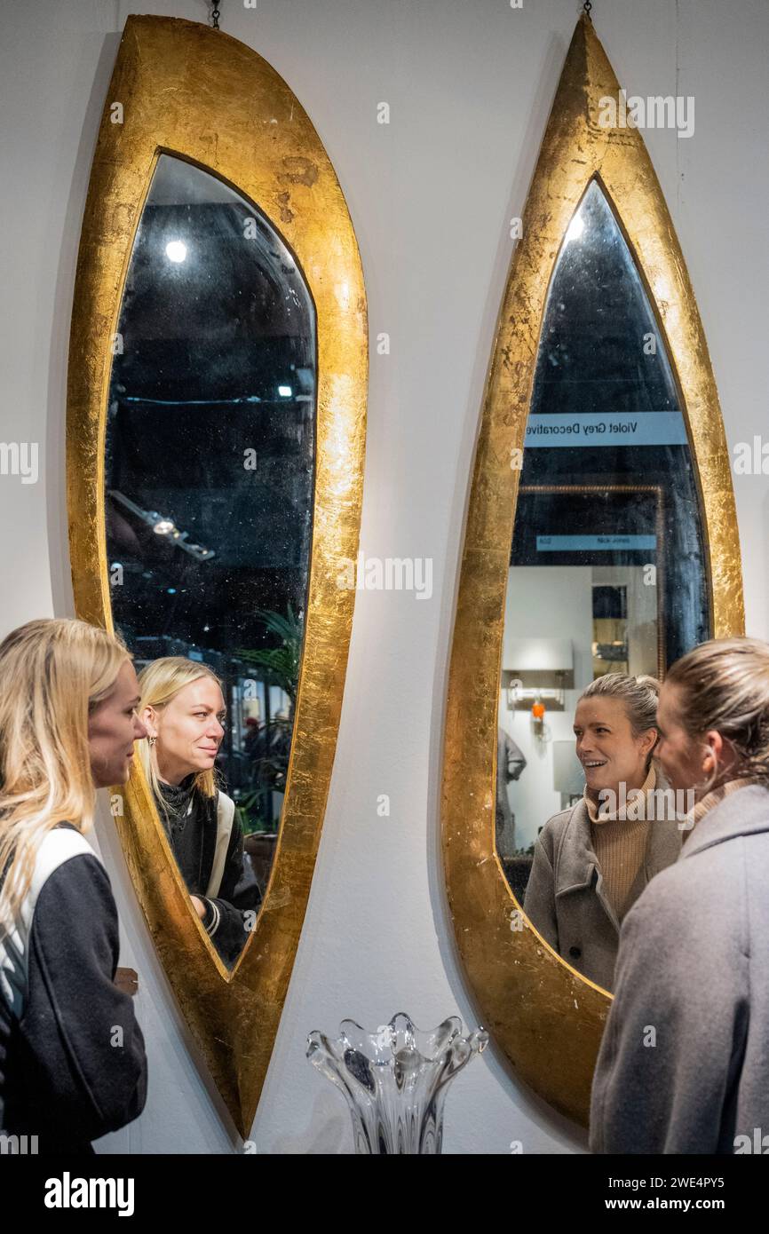 London, UK. 23 January 2024. Visitors in front of 'a pair of French elliptical gilt mirrors', c ...